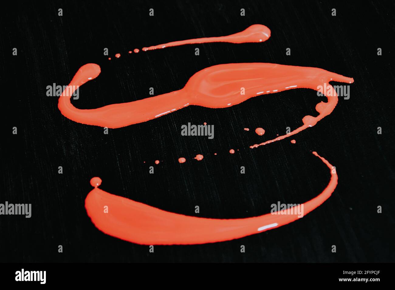 Closeup of red paint drips and splashes isolated on black background ...