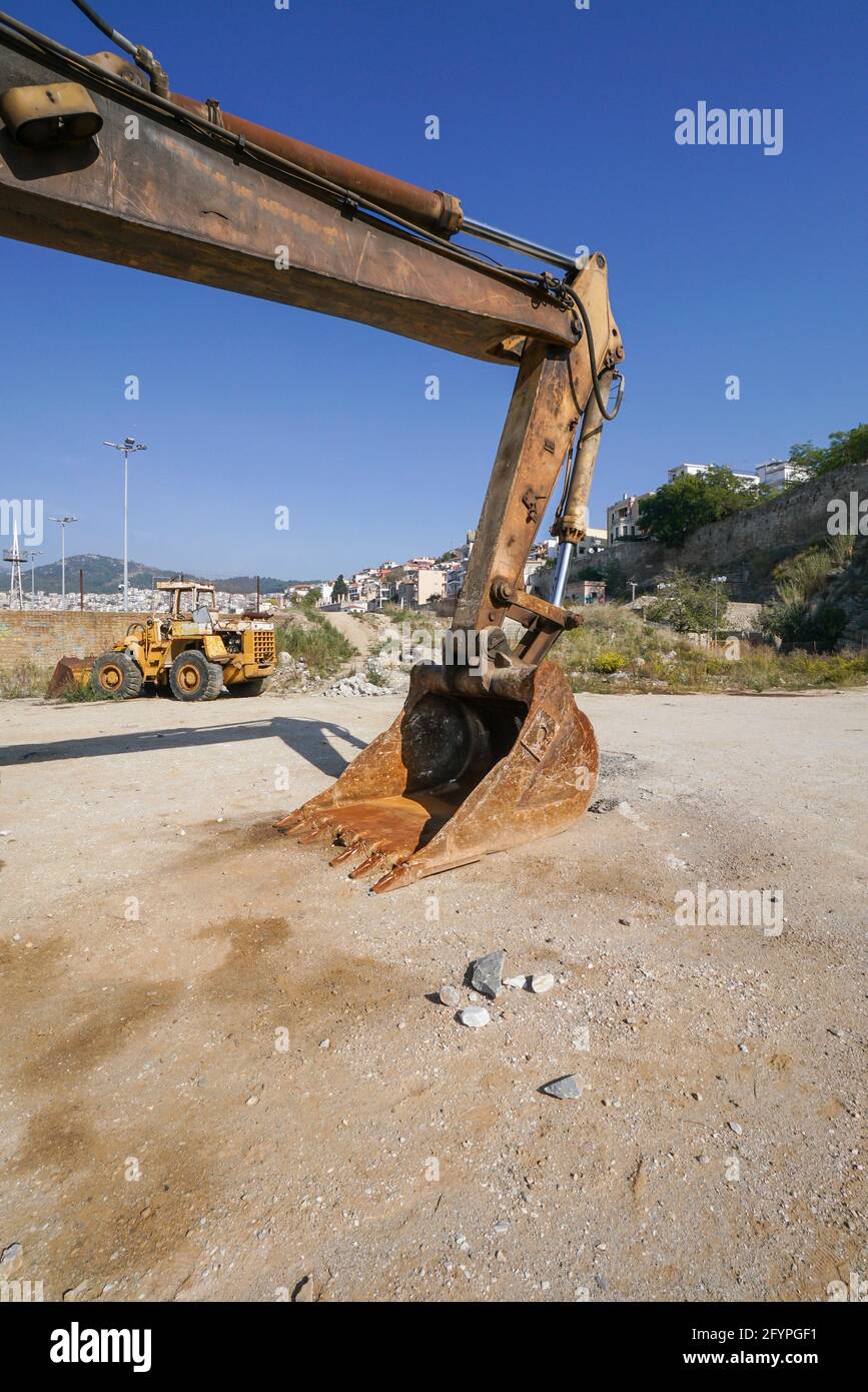 closeup an old and rusty excavator in a construction site in a sunny ...