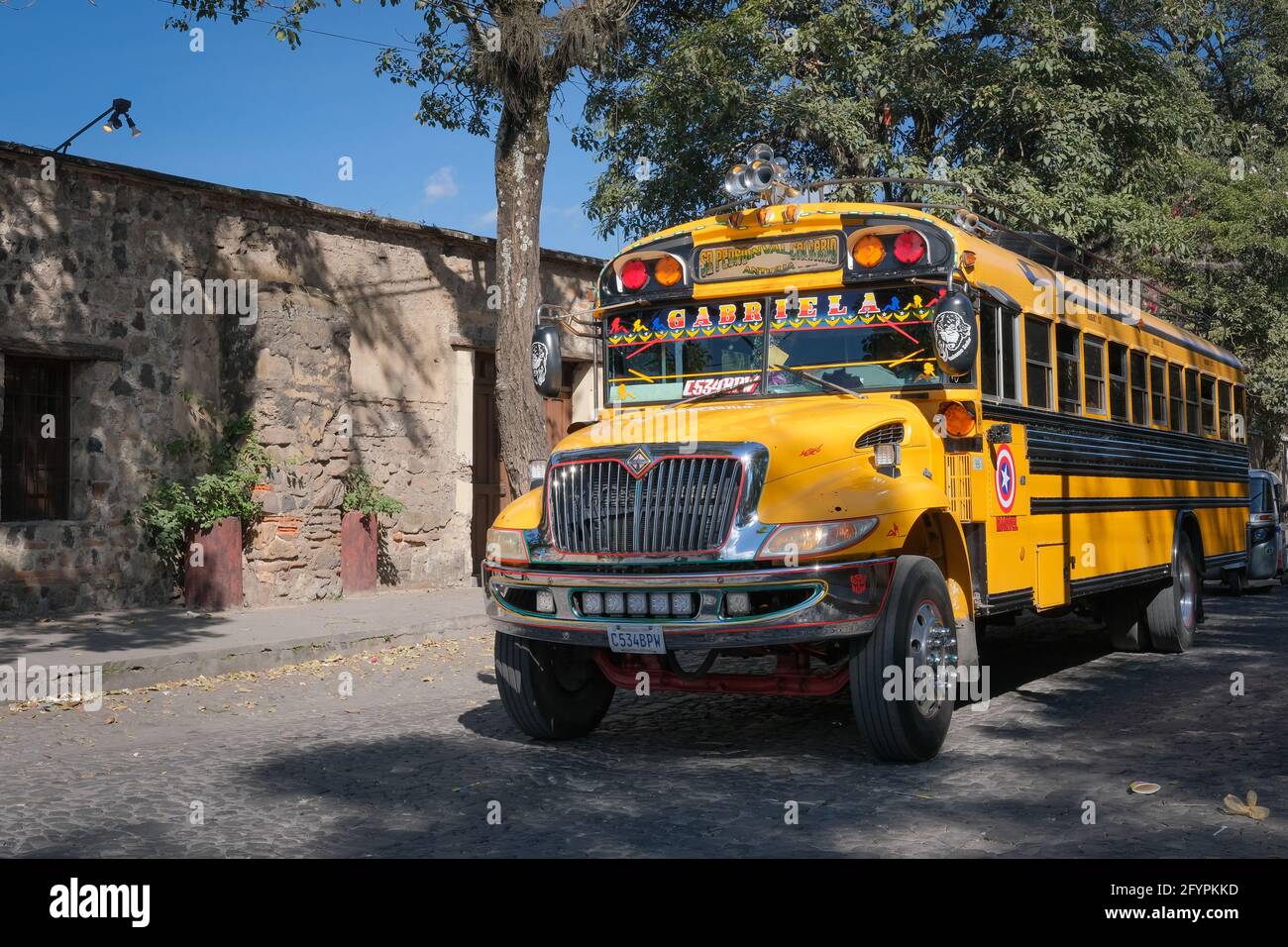 Bright yellow Guatemalan 'chicken bus' (local bus serving the small ...