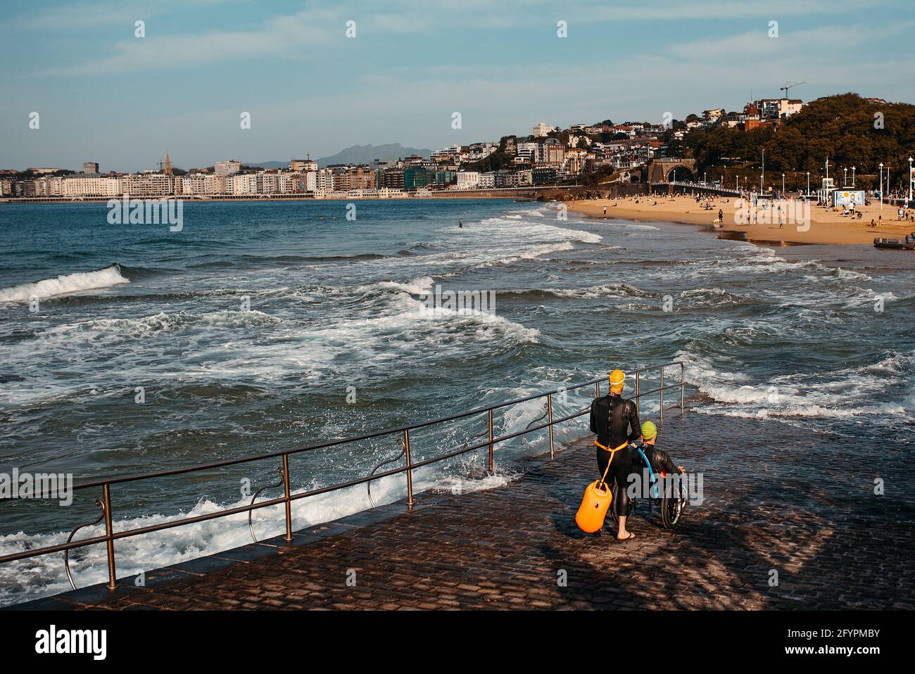 Handicap Disabled Man Going Down A Ramp To The Sea In Wheelchair Helped ...