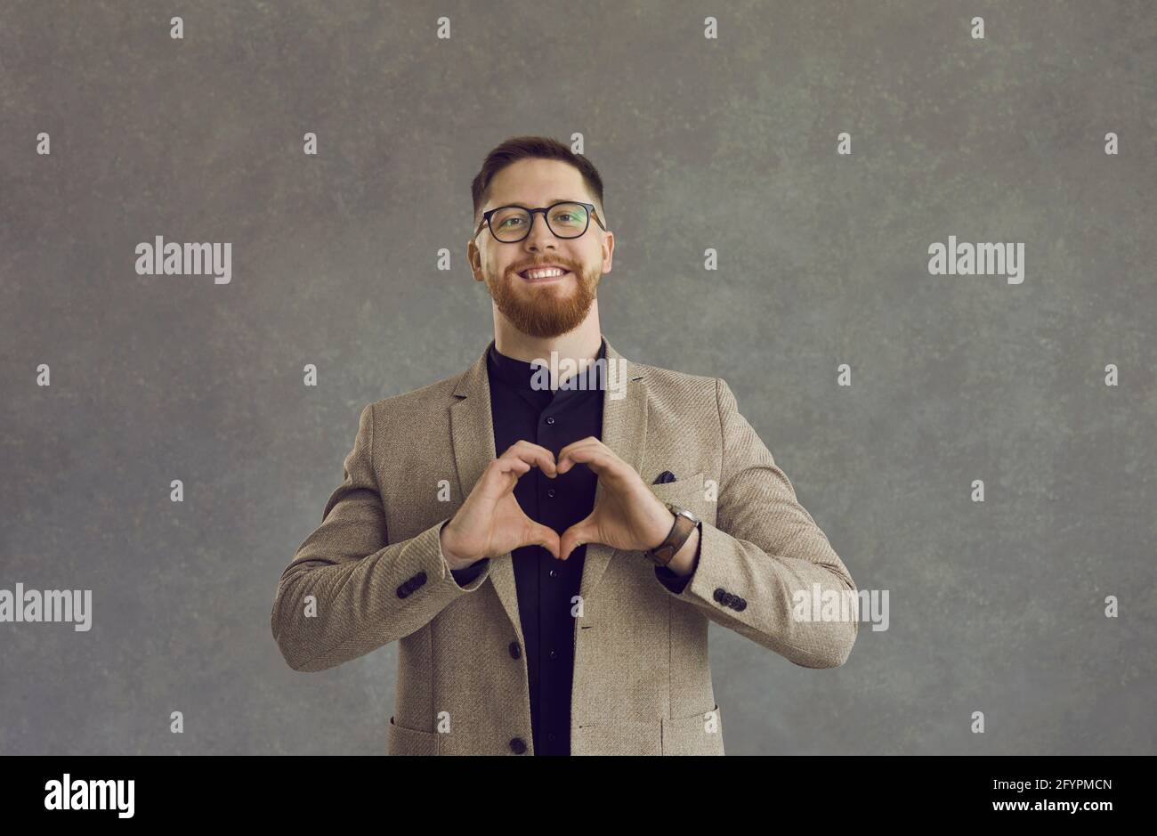 Adult caucasian business man making heart with hands showing love sign ...