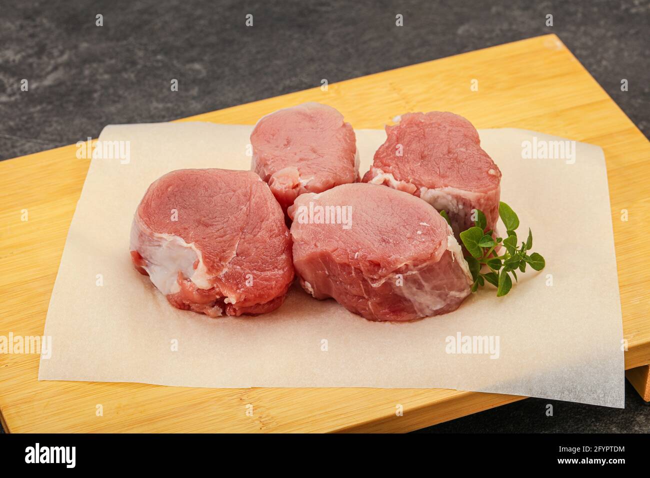 Raw pork medallion served rosemary for cooking Stock Photo - Alamy