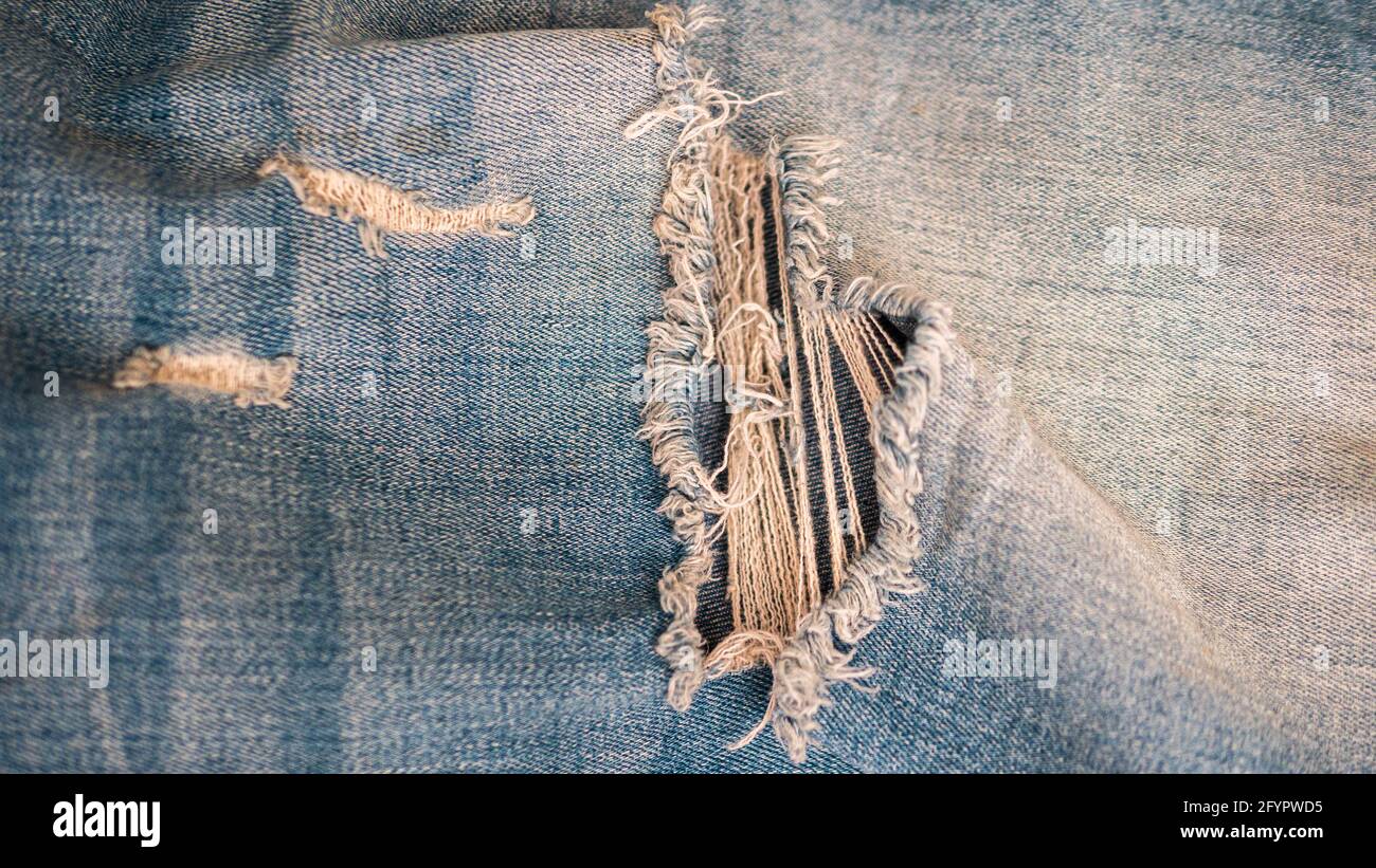 Denim background. Blue ripped jeans close-up. Denim Stock Photo - Alamy