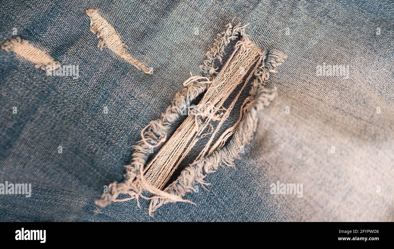 Denim background. Blue ripped jeans close-up. Denim Stock Photo - Alamy