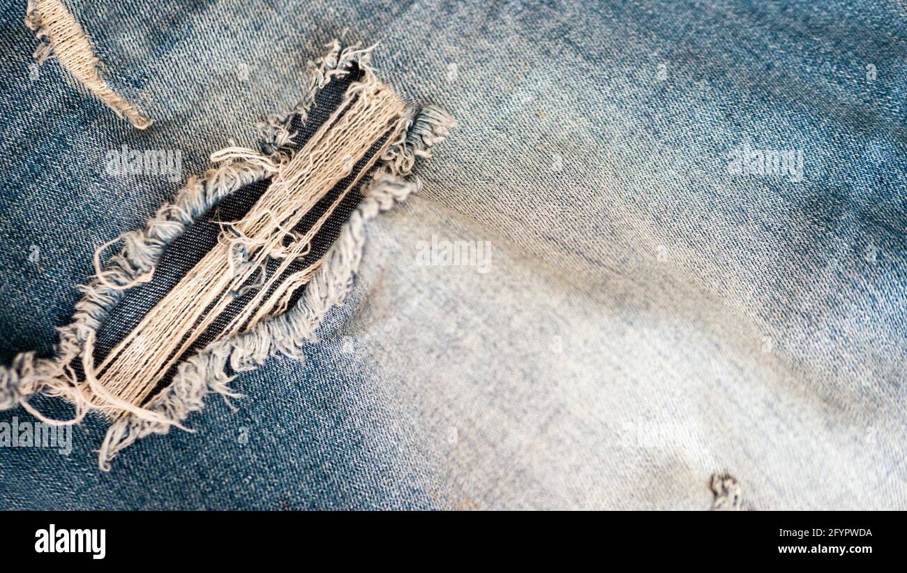 Denim background. Blue ripped jeans close-up. Denim Stock Photo - Alamy