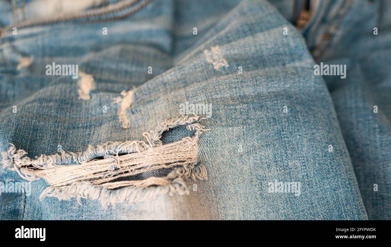 Denim background. Blue ripped jeans close-up. Denim Stock Photo - Alamy