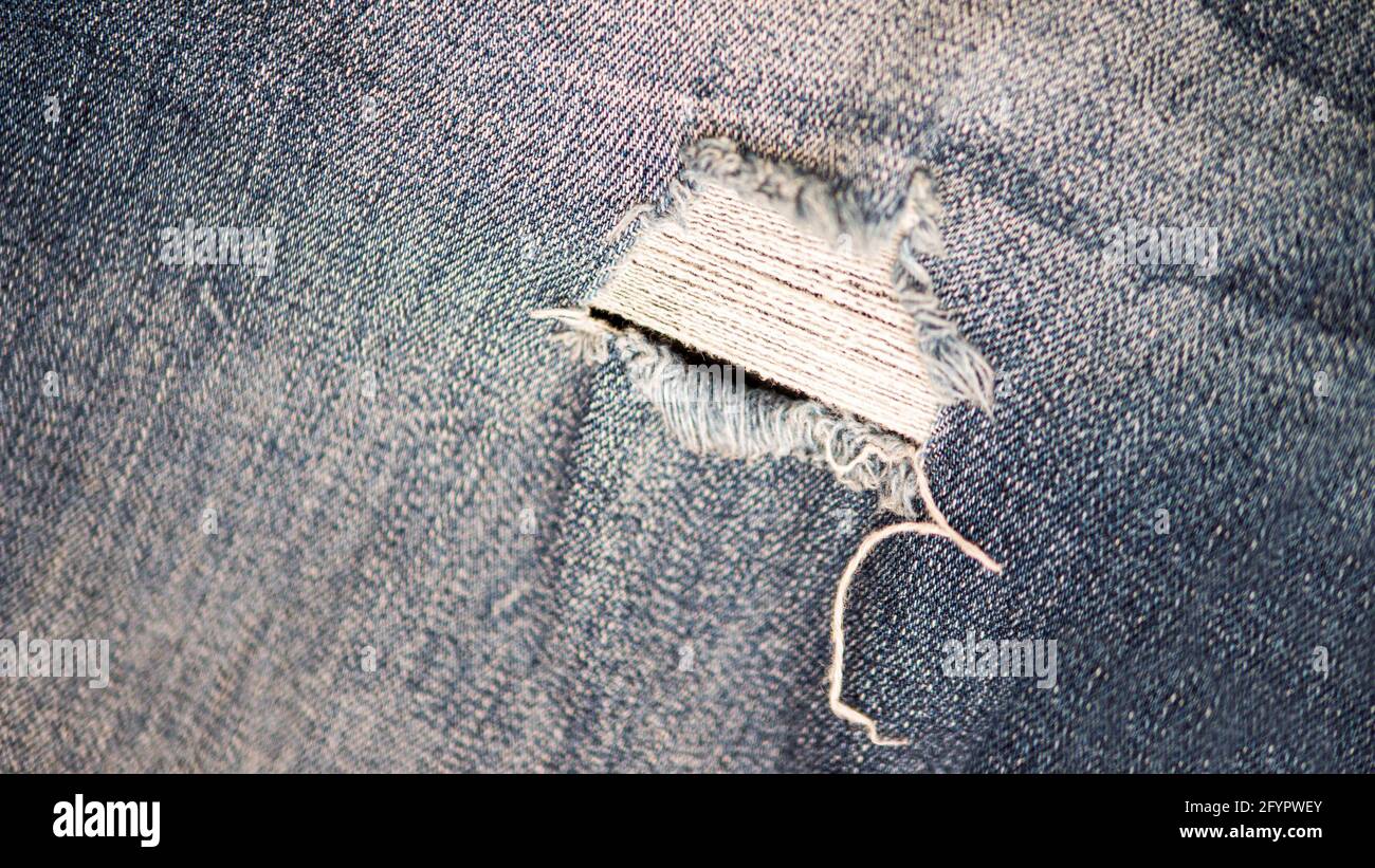 Denim background. Blue ripped jeans close-up. Denim Stock Photo - Alamy
