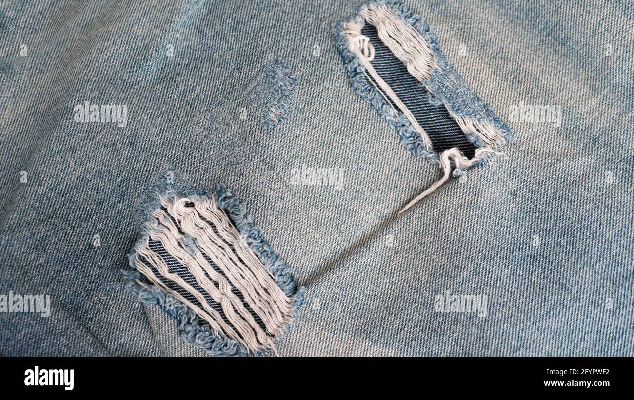 Denim background. Blue ripped jeans close-up. Denim Stock Photo - Alamy