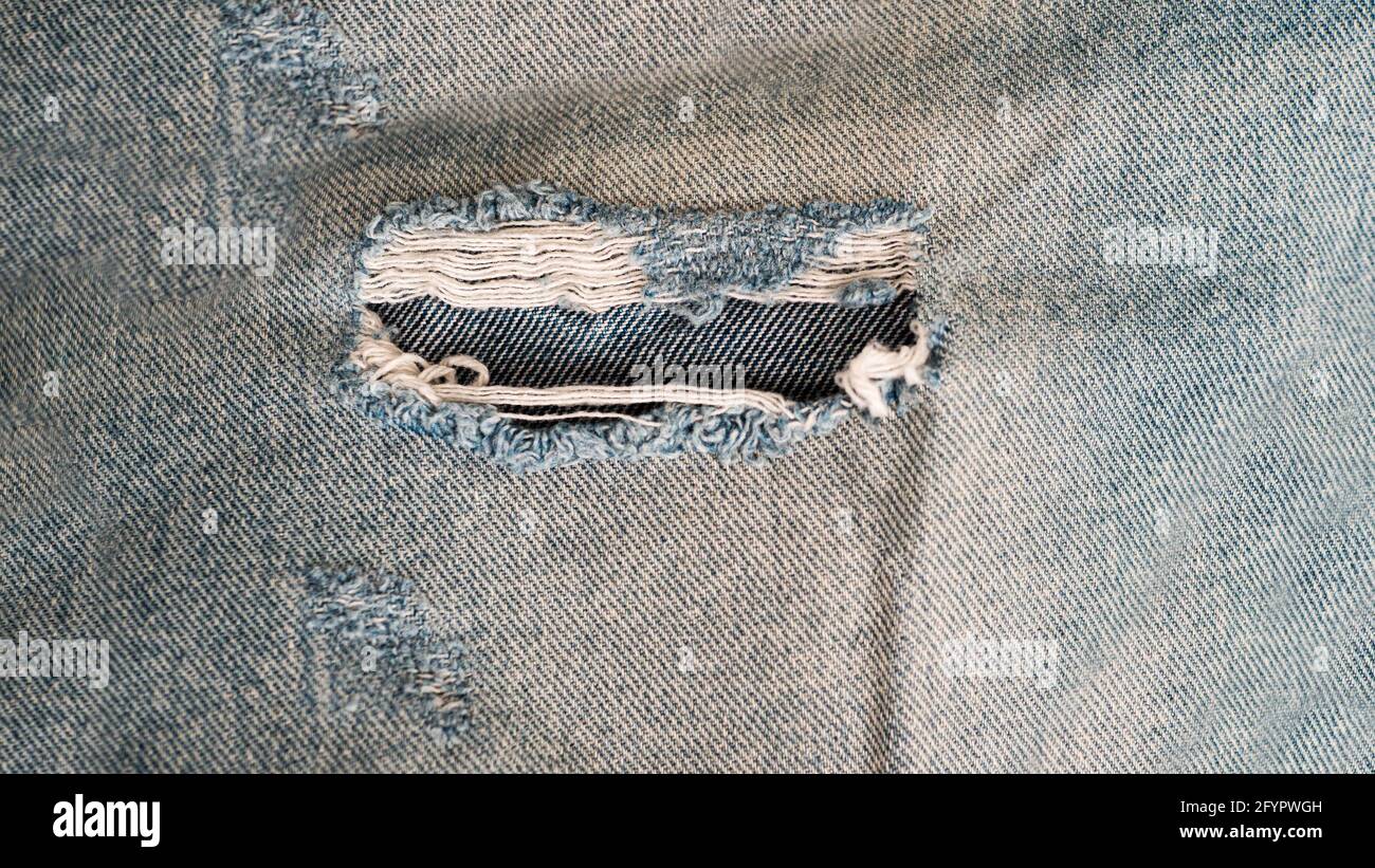 Denim background. Blue ripped jeans close-up. Denim Stock Photo - Alamy