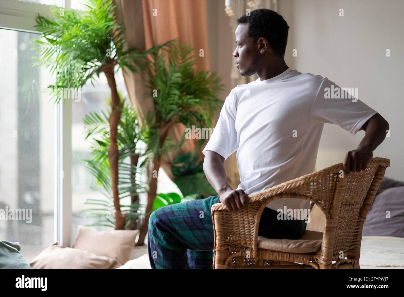 Sporty young african man practicing yoga using chair, doing Revolved ...