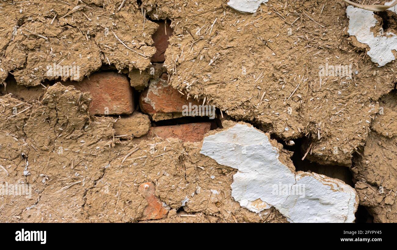 A wall of ruined, an ancient wall of clay and straw and brick. Hut wall ...