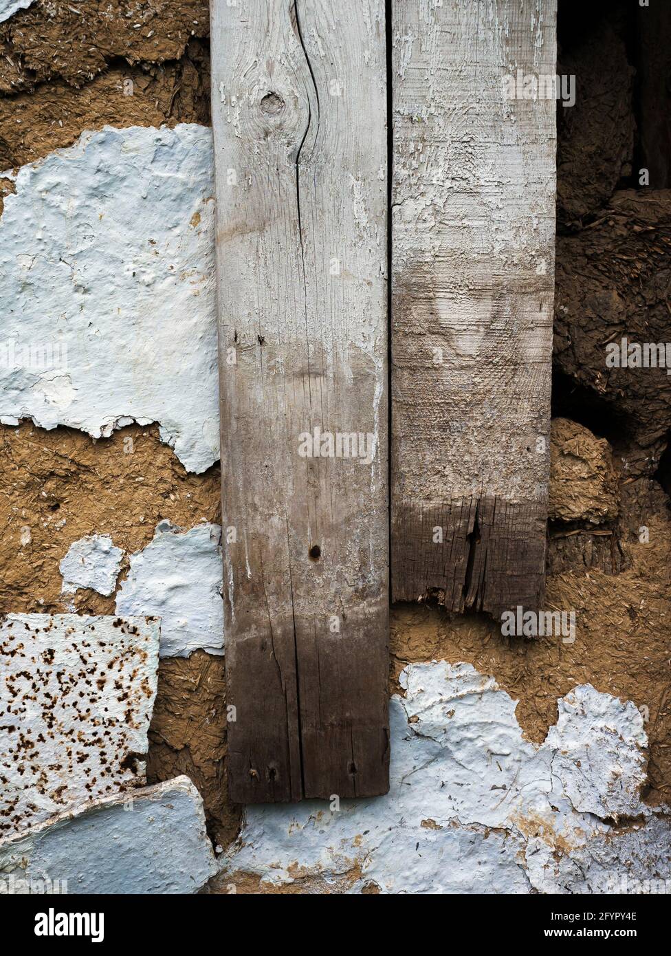 Ancient wall made of clay with boards. A vertical picture of an old ...