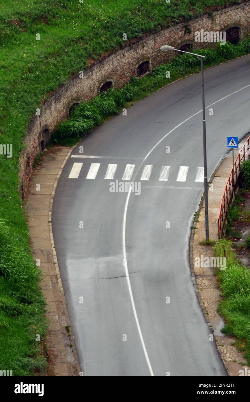 Close-up shot of curvy road with a pedestrian crossing Stock Photo - Alamy