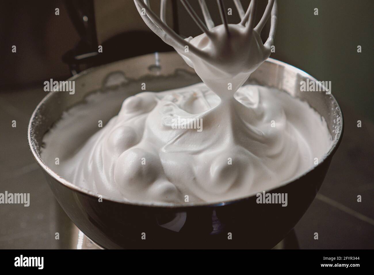Selective focus shot of a dough cooking process in a metallic bowl ...