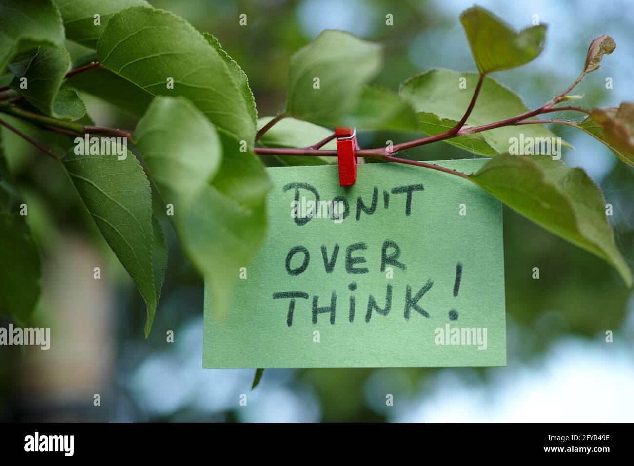A paper note with the phrase Don't over think written on it hanging on ...