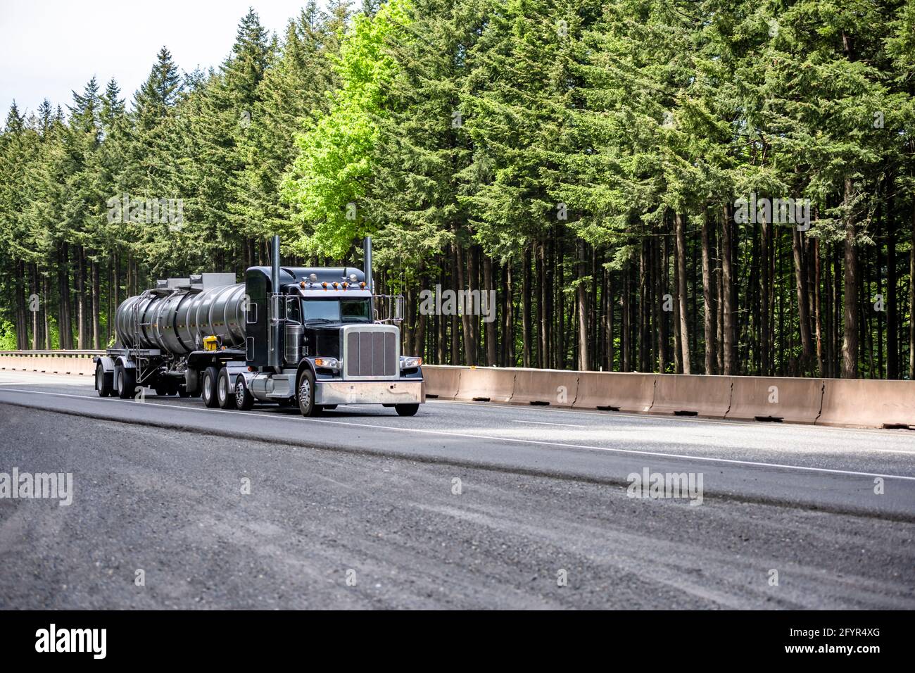 Black classic big rig industrial semi truck tractor transporting liquid ...
