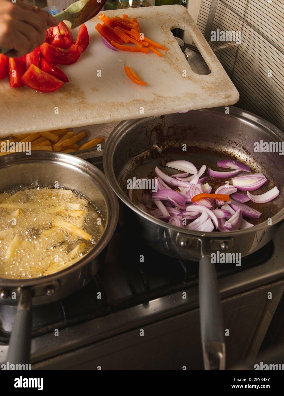 Vertical shot of a hand adding ingredients to the pot for frying Stock ...