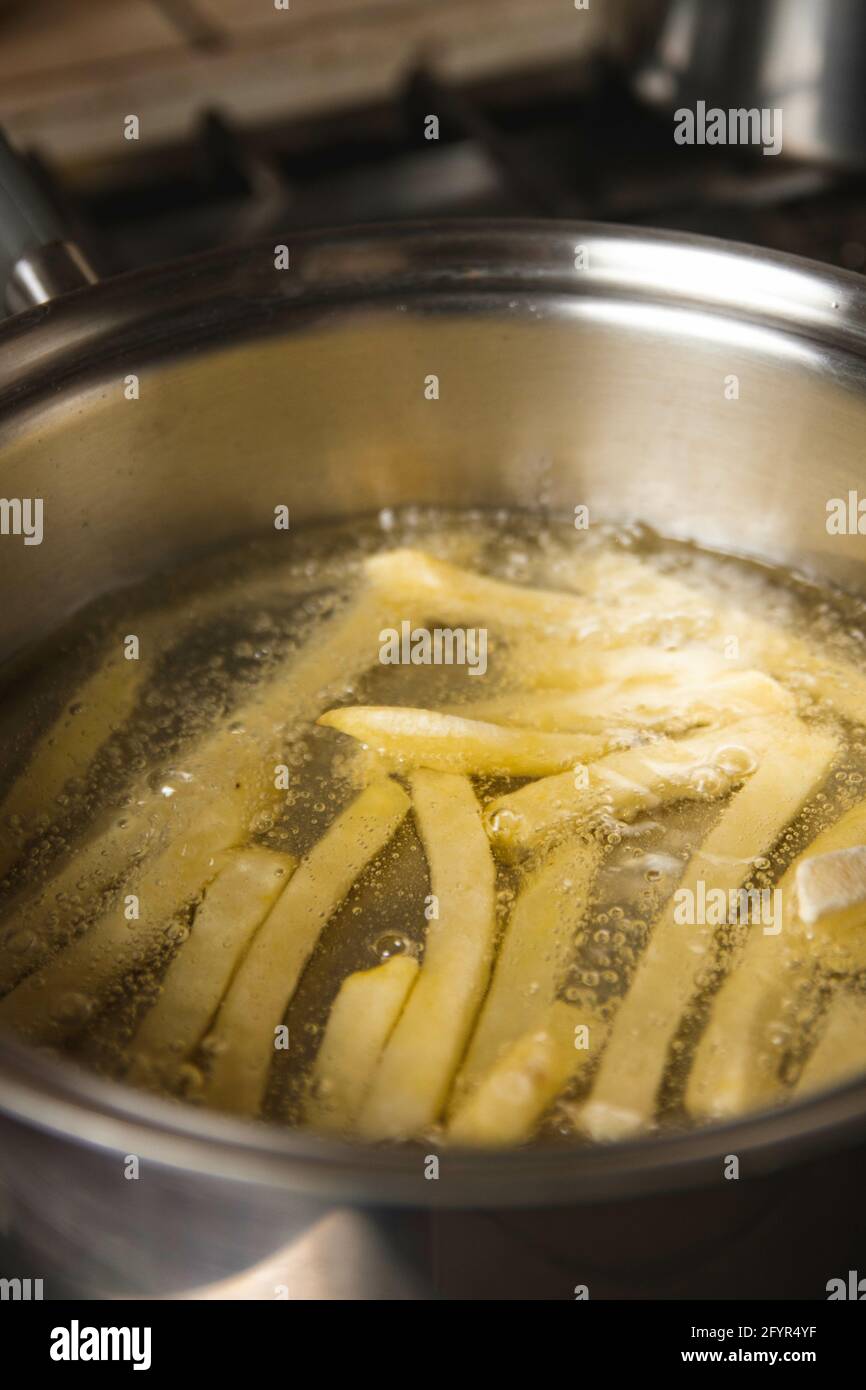 Vertical shot of a pot full of french fries frying in the oil Stock ...