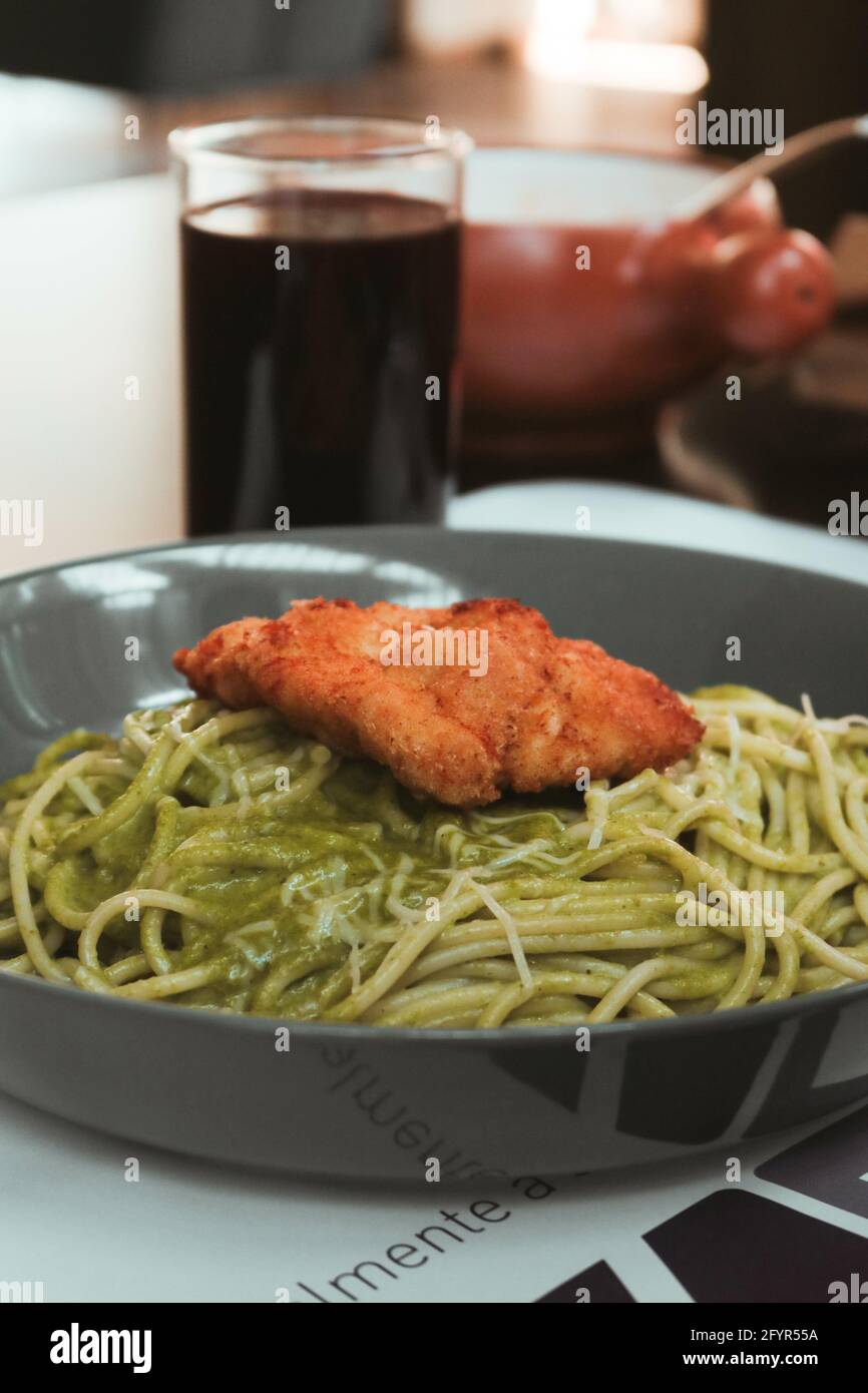 Vertical shot of appetizing pesto pasta with parmesan cheese and ...
