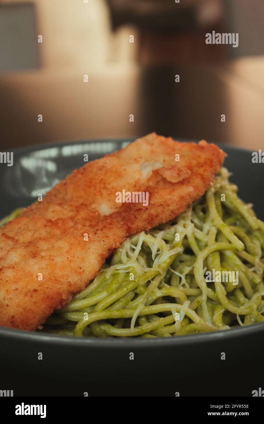 Vertical shot of appetizing pesto pasta with parmesan cheese and ...