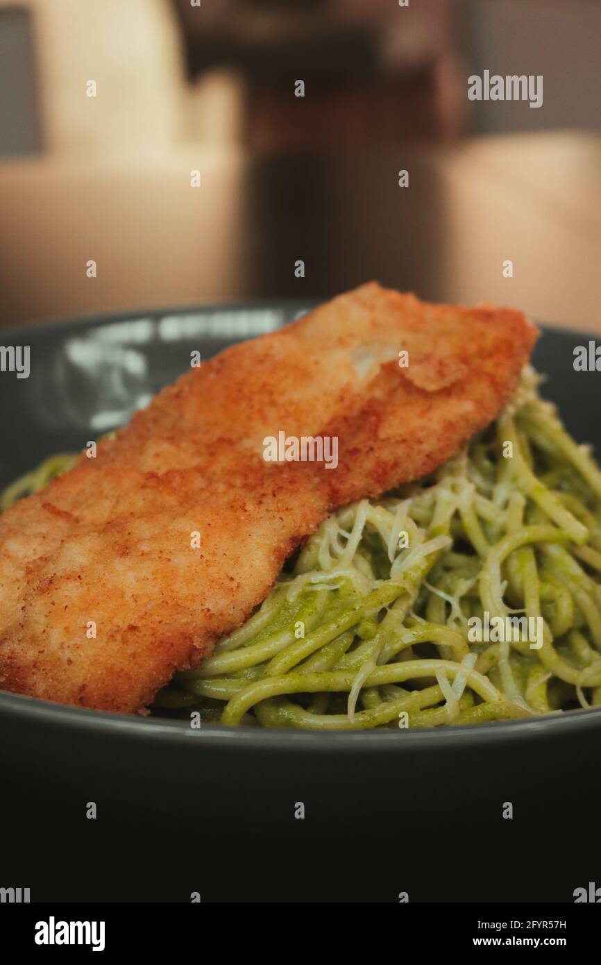 Vertical shot of appetizing pesto pasta with parmesan cheese and ...