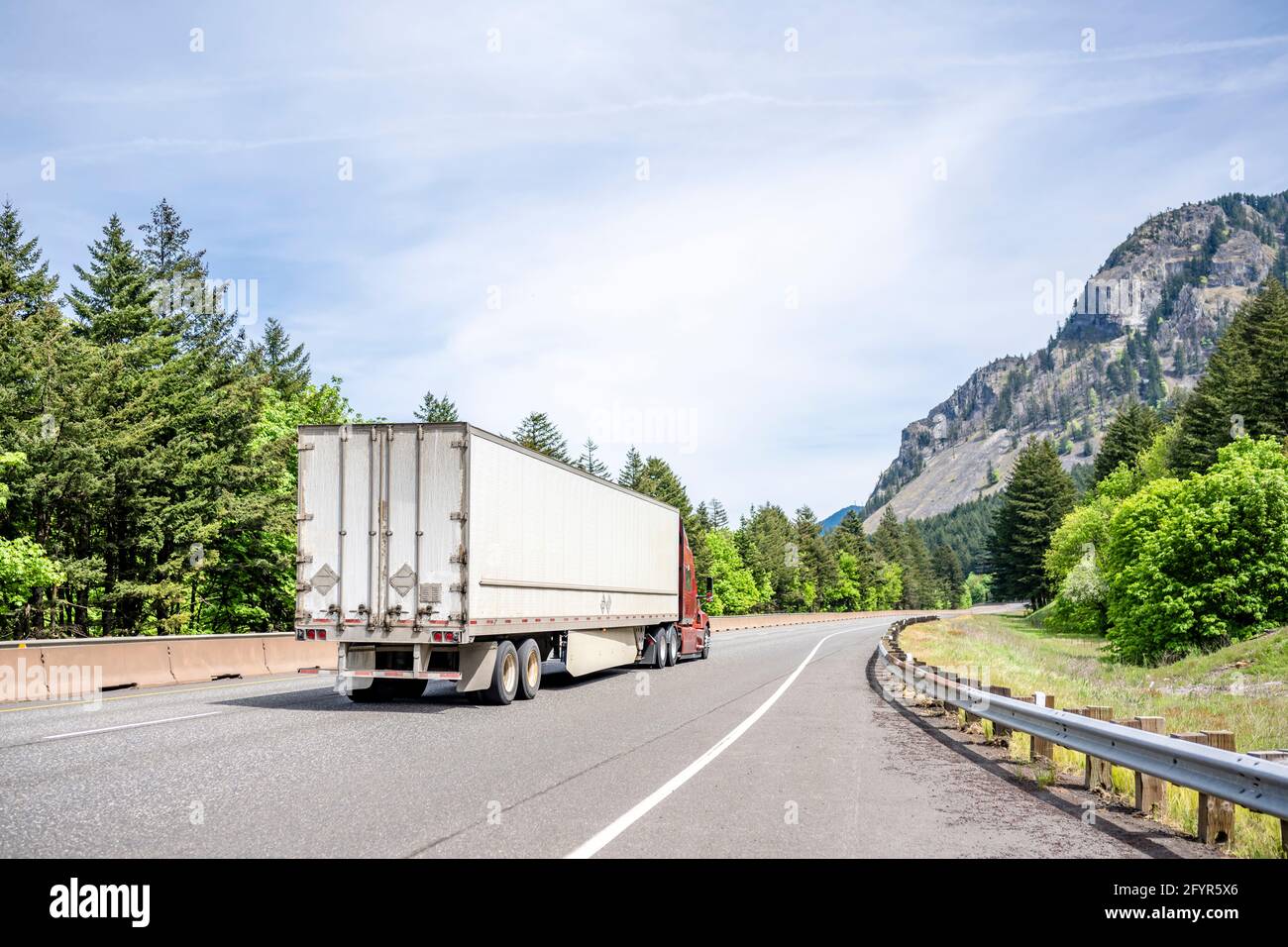Red big rig long haul industrial semi truck tractor transporting cargo ...