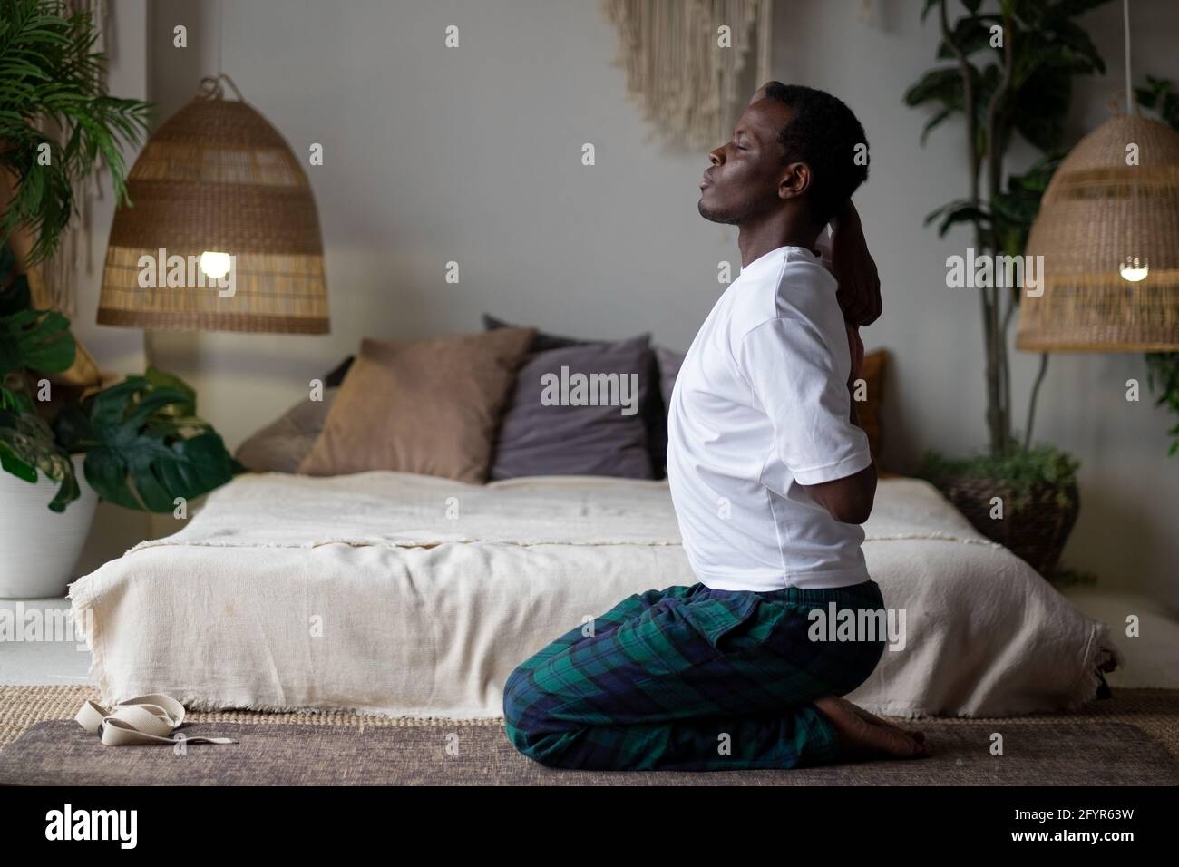 Young african man making asana exercises for shoulders stretching Stock ...