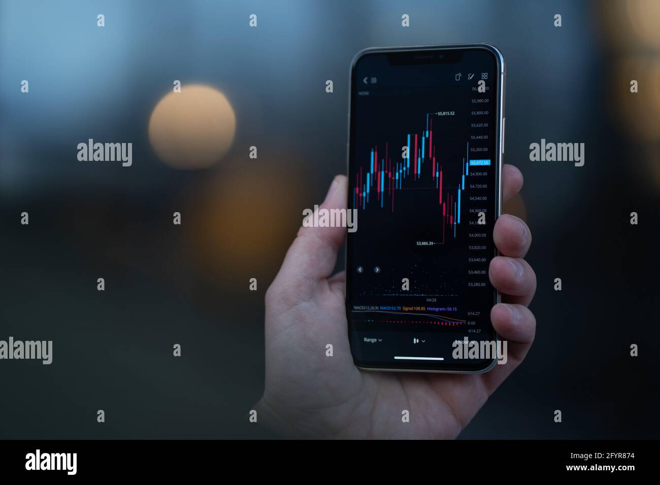 Trader looking at mobile phone with stock chart on screen Stock Photo ...