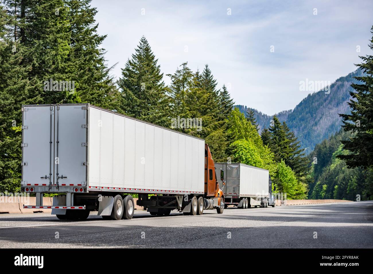 Two big rig industrial semi truck tractors transporting commercial ...