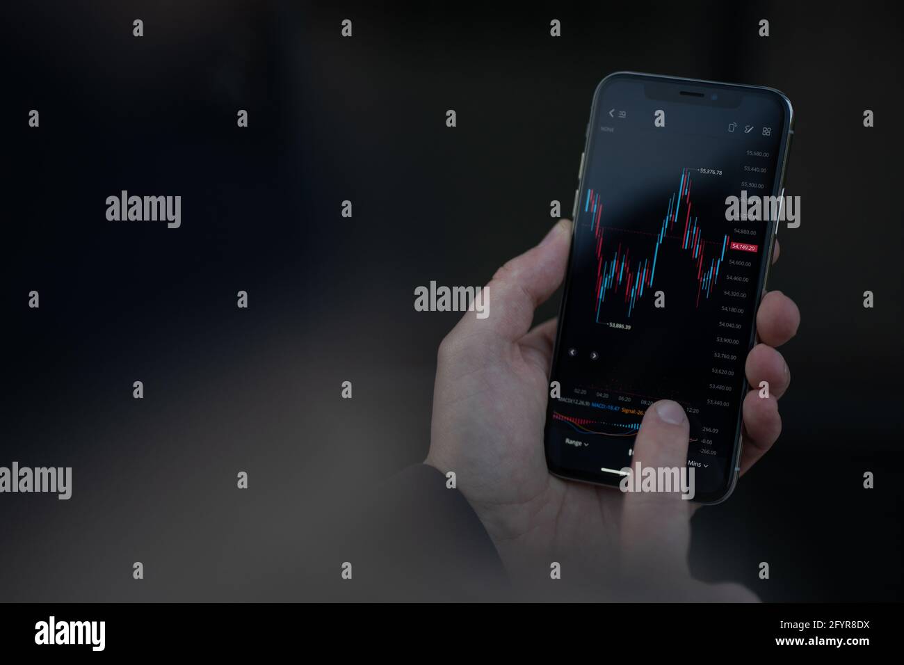 Male hand touching smartphone screen with financial graph chart Stock ...