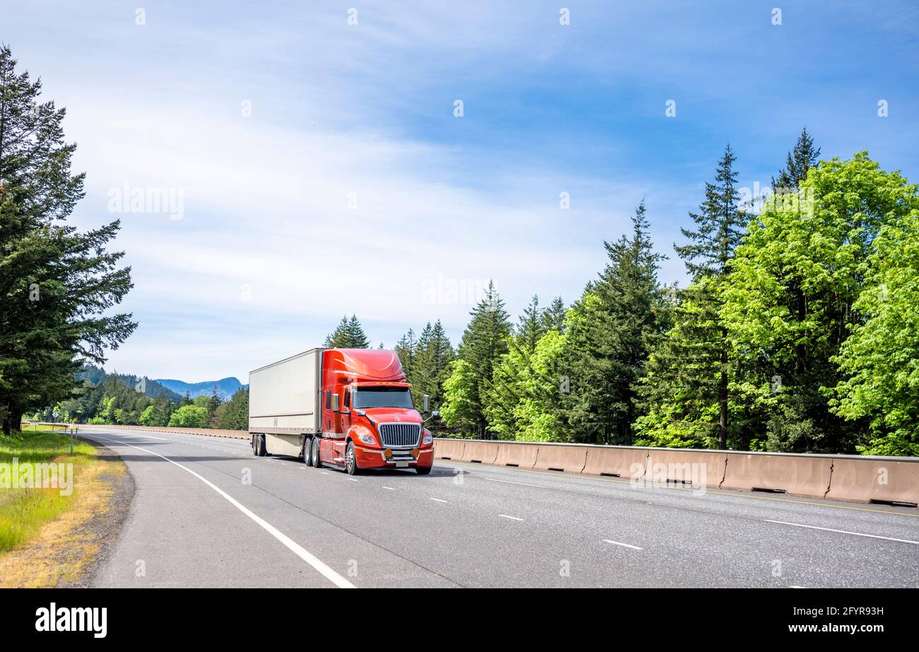 Red big rig long haul industrial semi truck tractor transporting cargo ...