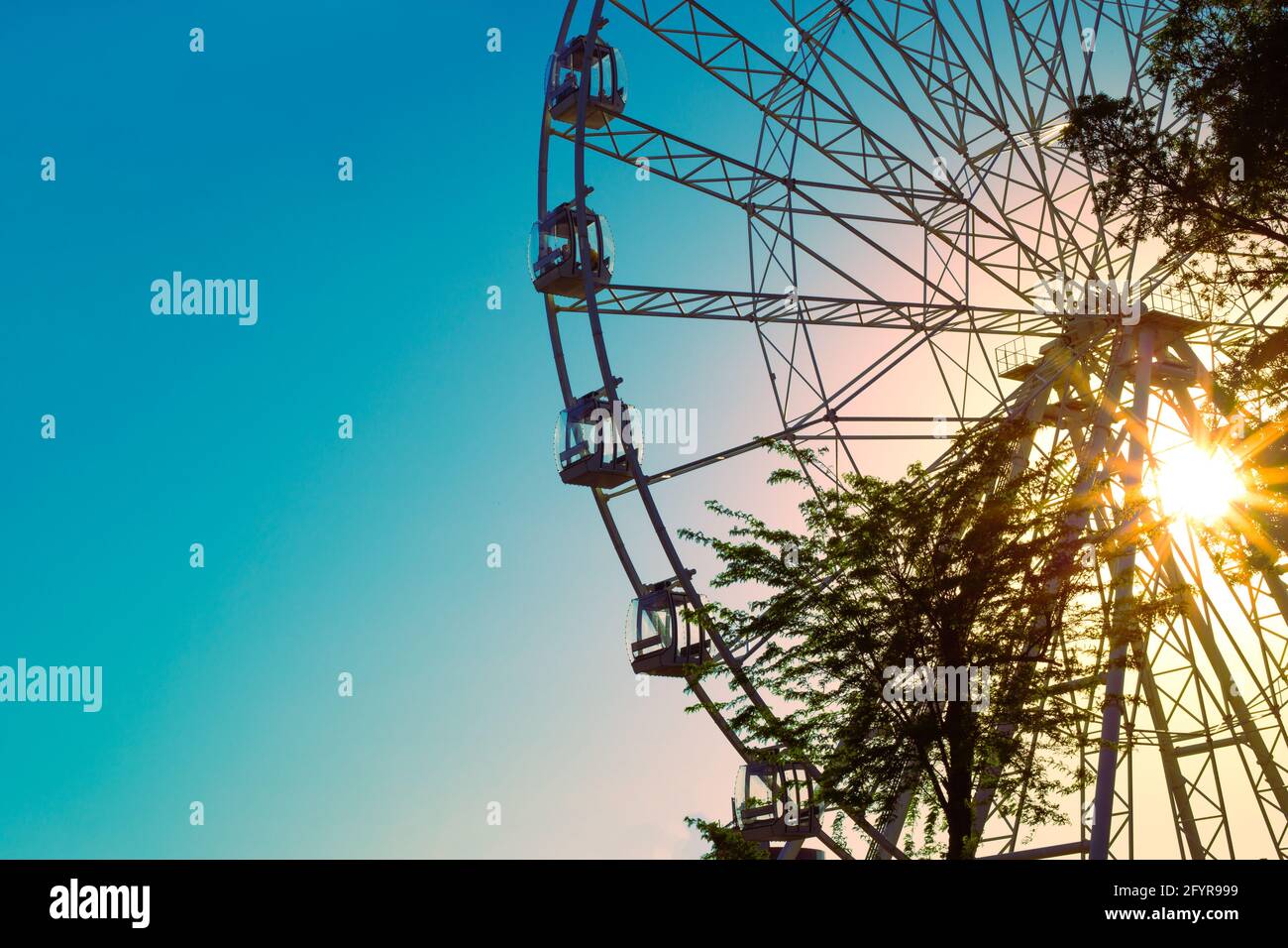 Ferris wheel in the park with rays of the glowing sun, copy space ...