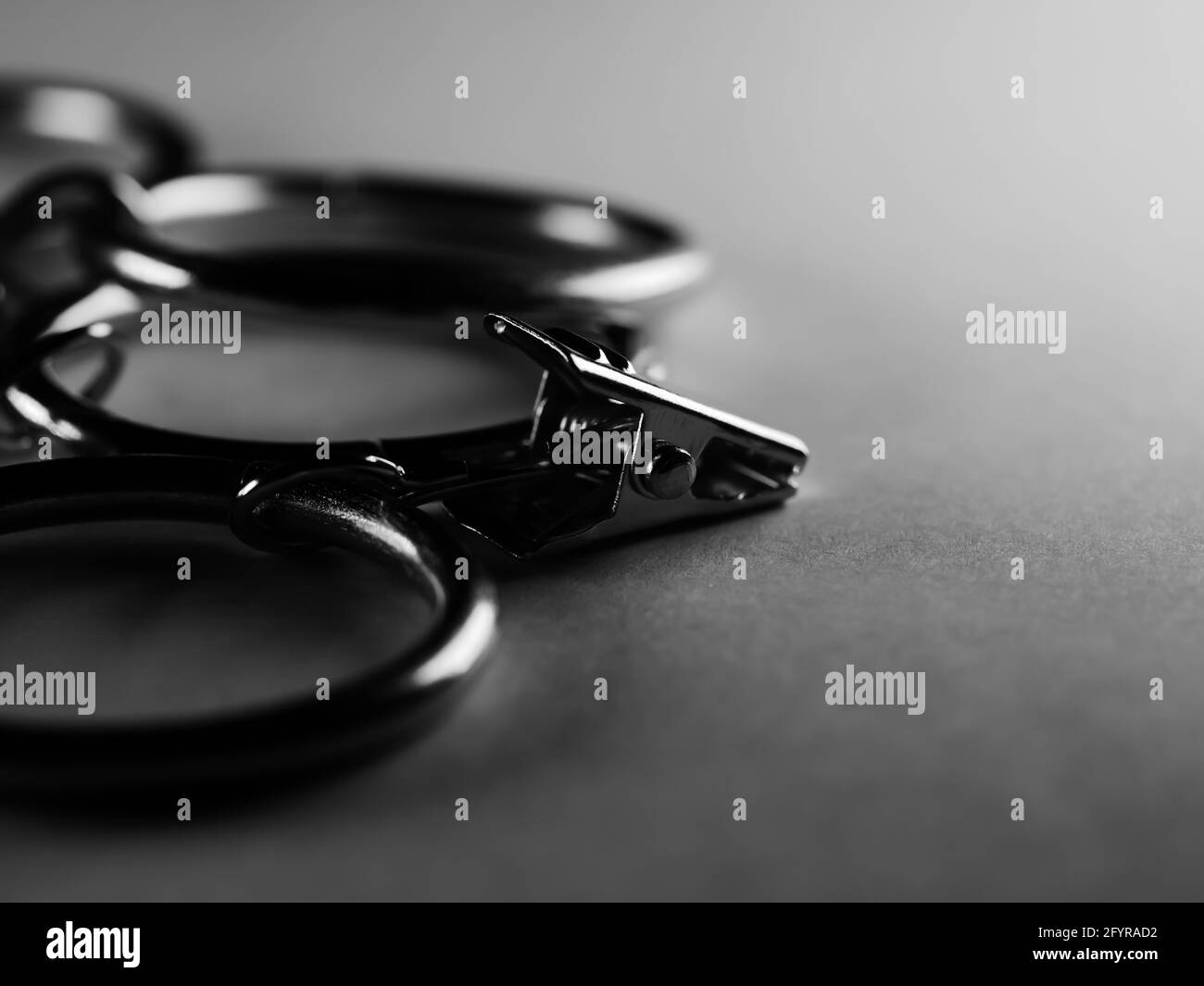 Dramatic grayscale shot of curtain metal rod clip rings Stock Photo - Alamy
