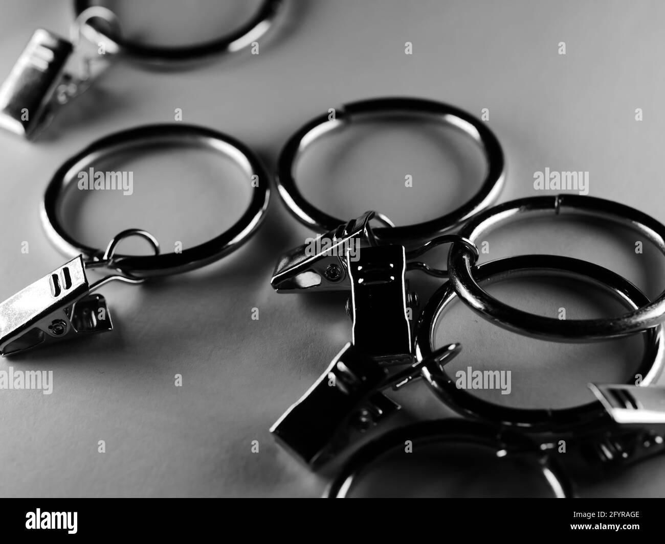 Dramatic grayscale shot of curtain metal rod clip rings Stock Photo - Alamy