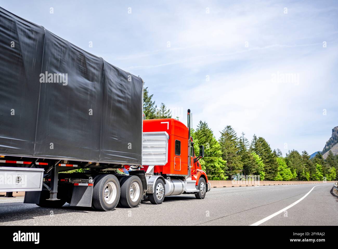 Red big rig long haul industrial semi truck tractor transporting cargo ...