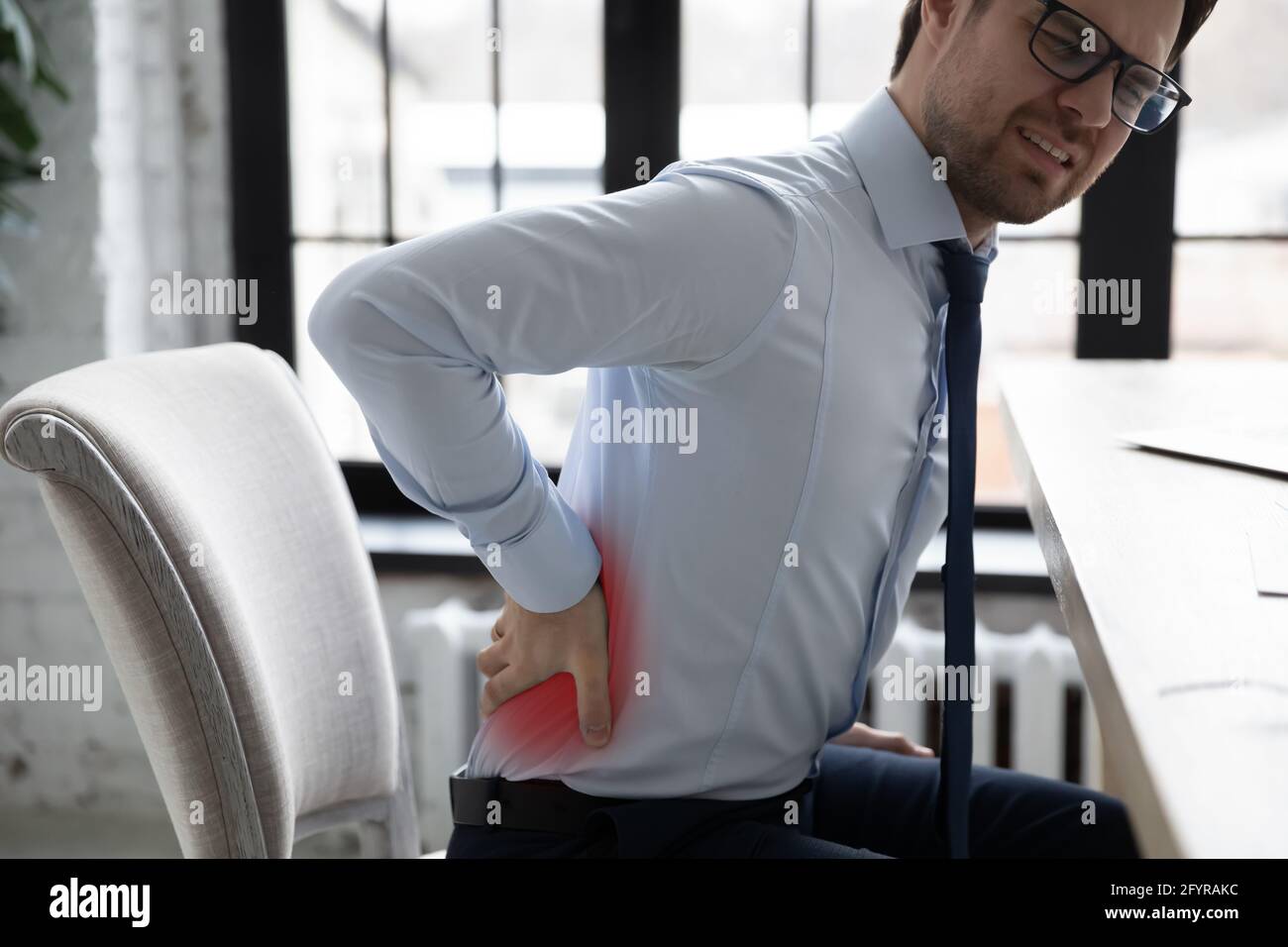 Unhappy office worker suffering from back pain attack Stock Photo - Alamy