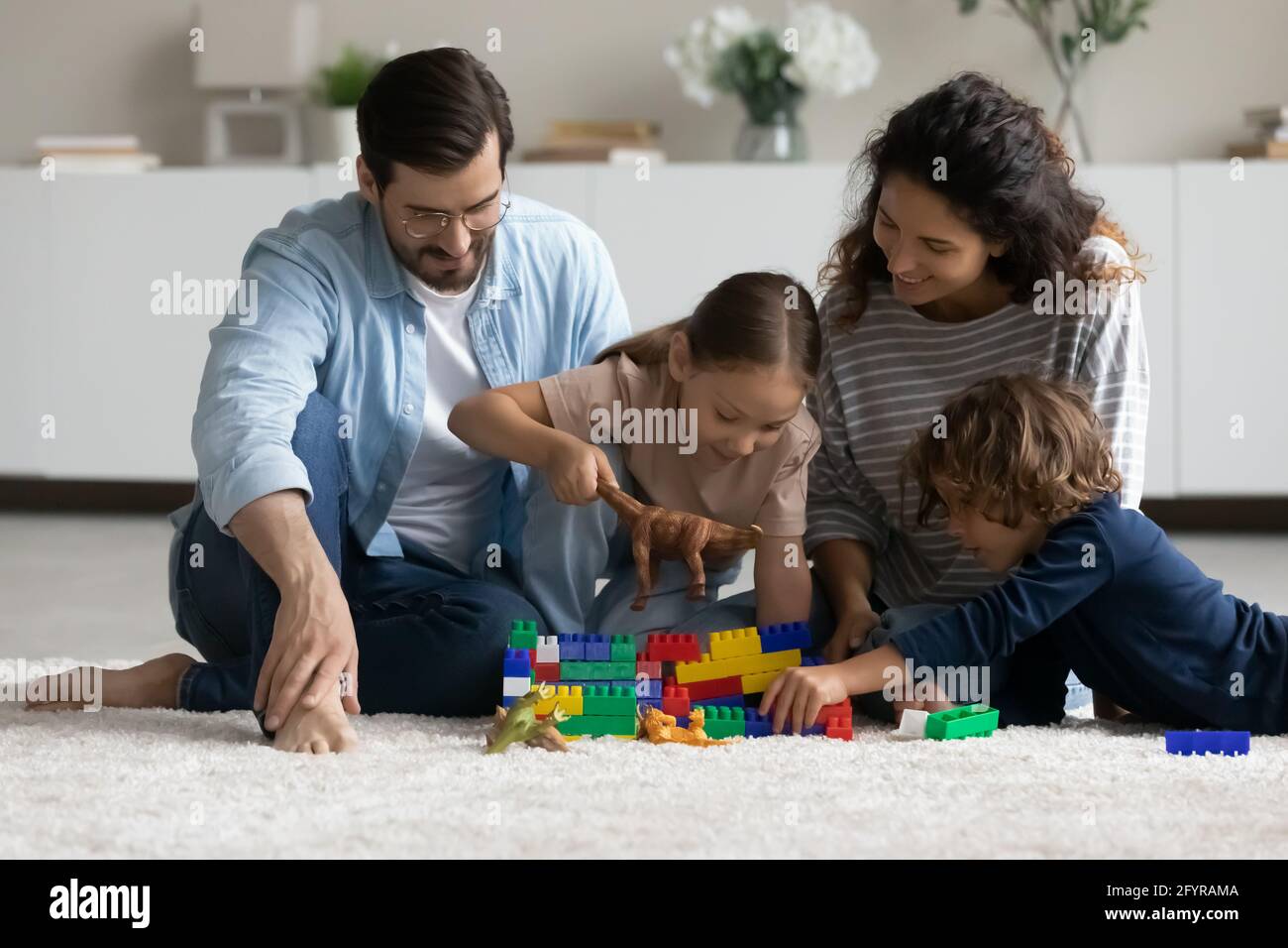 Happy multiracial parents play with small children Stock Photo - Alamy