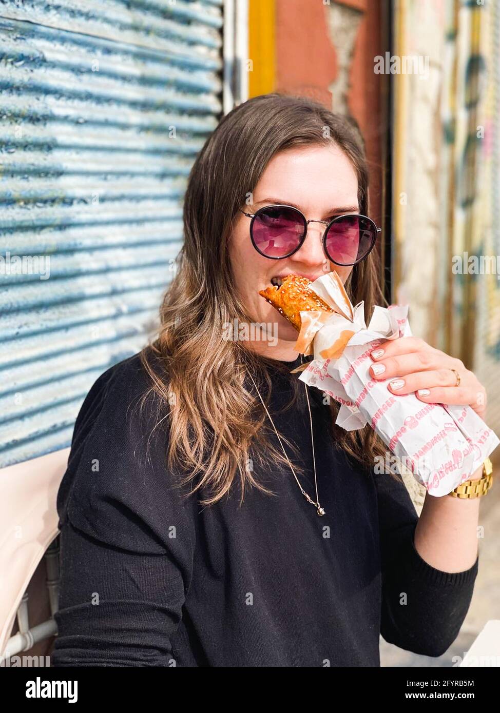 woman on the street eating shawarma roll Stock Photo - Alamy