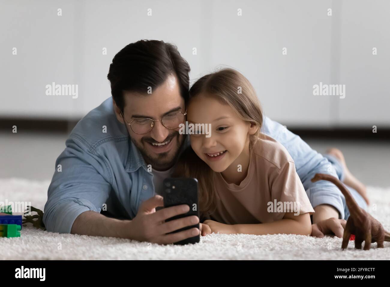 Happy young dad and small daughter use smartphone Stock Photo - Alamy