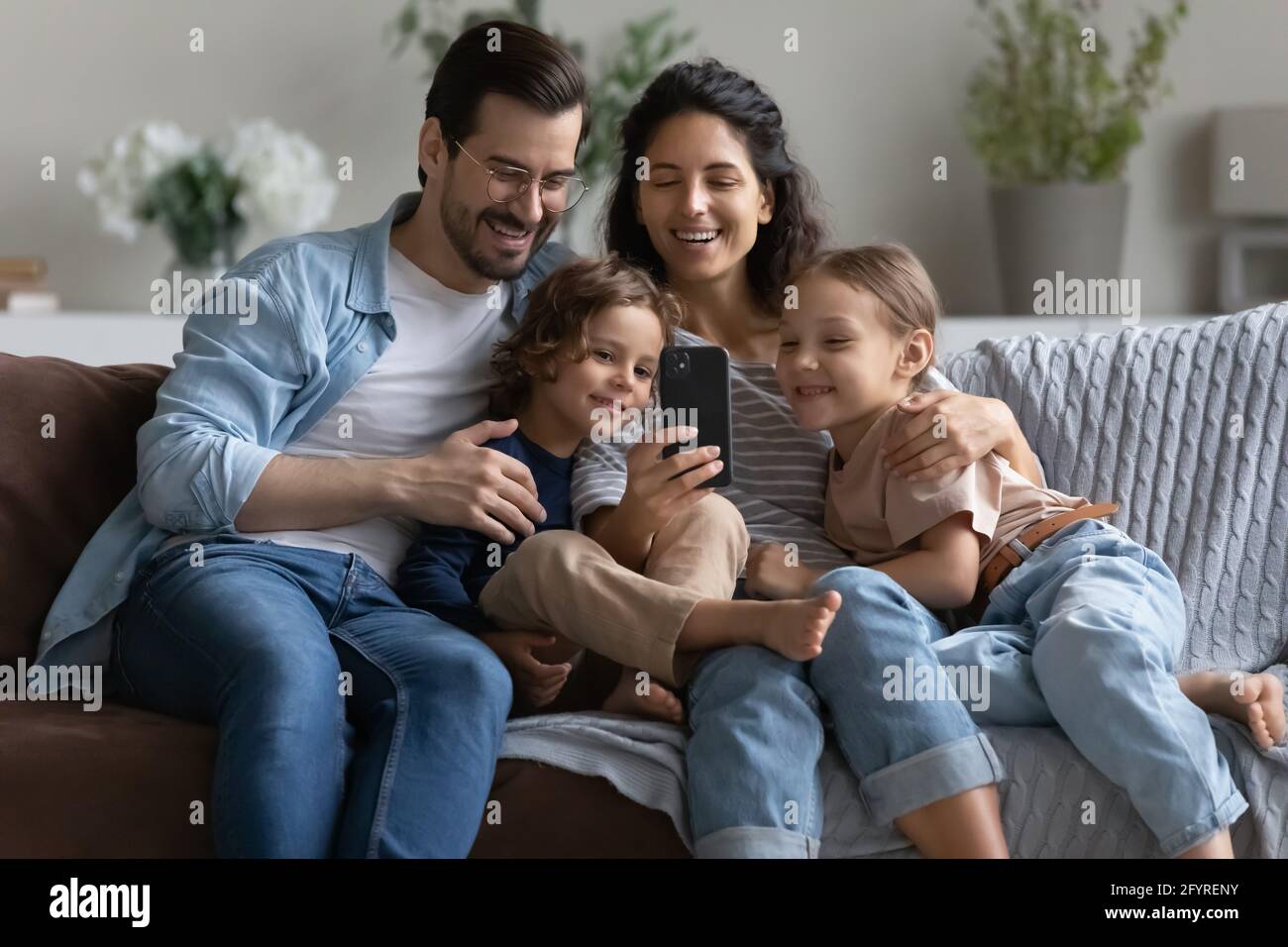 Happy family with kids use modern smartphone Stock Photo - Alamy