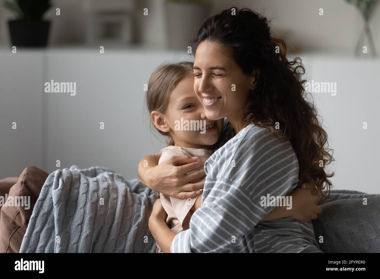 Loving Hispanic mom hug small biracial daughter Stock Photo - Alamy