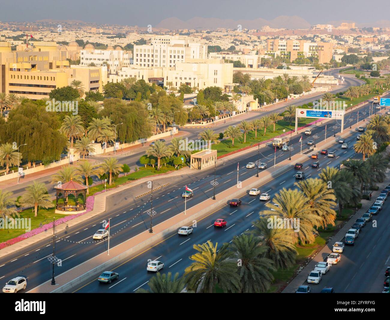 The low-rise, beige colored skyline of Muscat and roadways, streets in ...