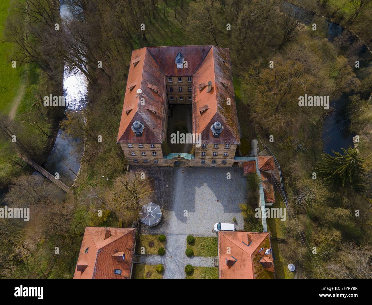 An aerial view of a medieval castle with red rooftops surrounded by ...