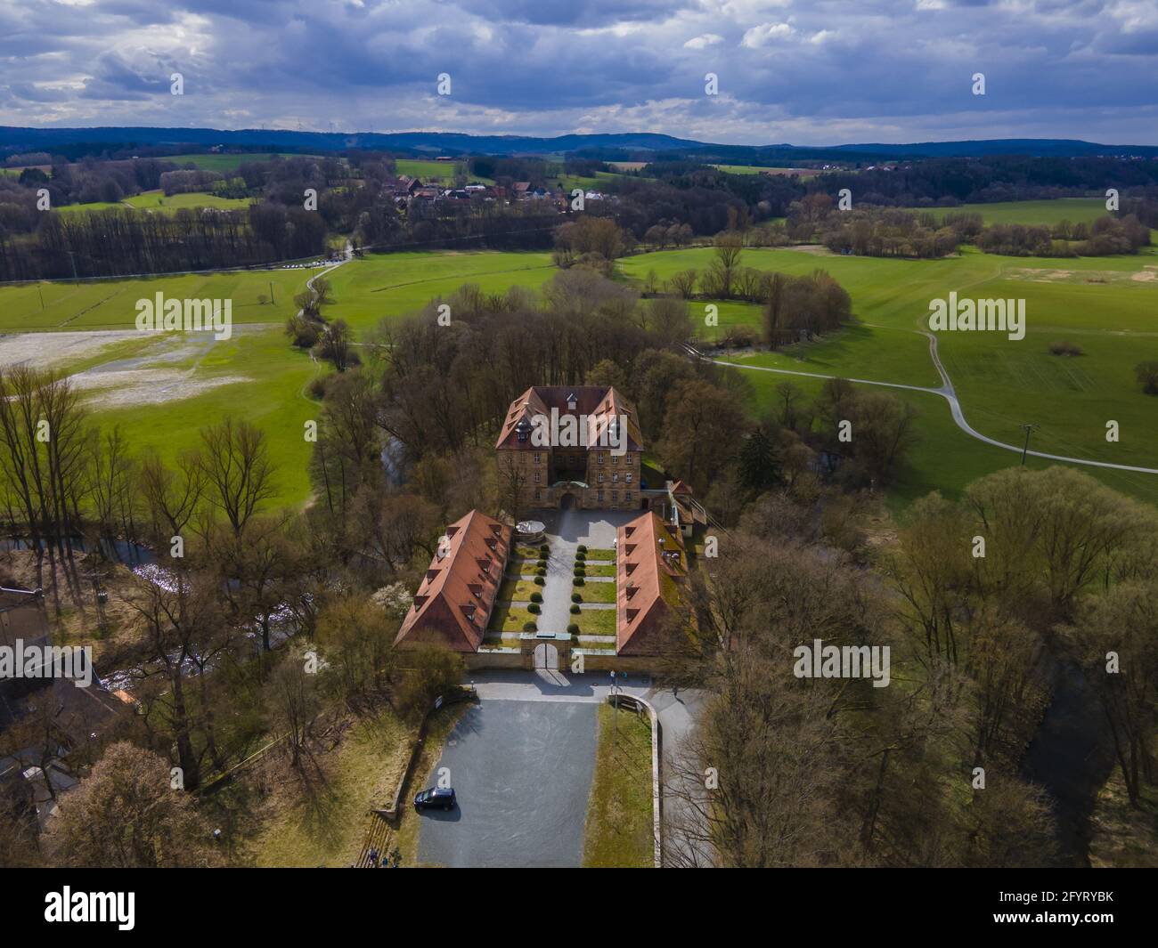 An aerial view of a medieval castle with red rooftops surrounded by ...