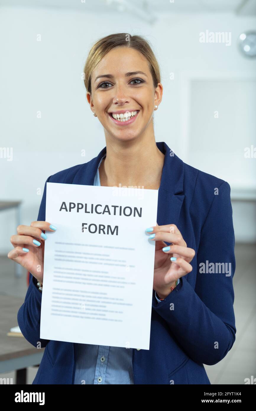 Successful applicant holding up her application form with a beaming ...