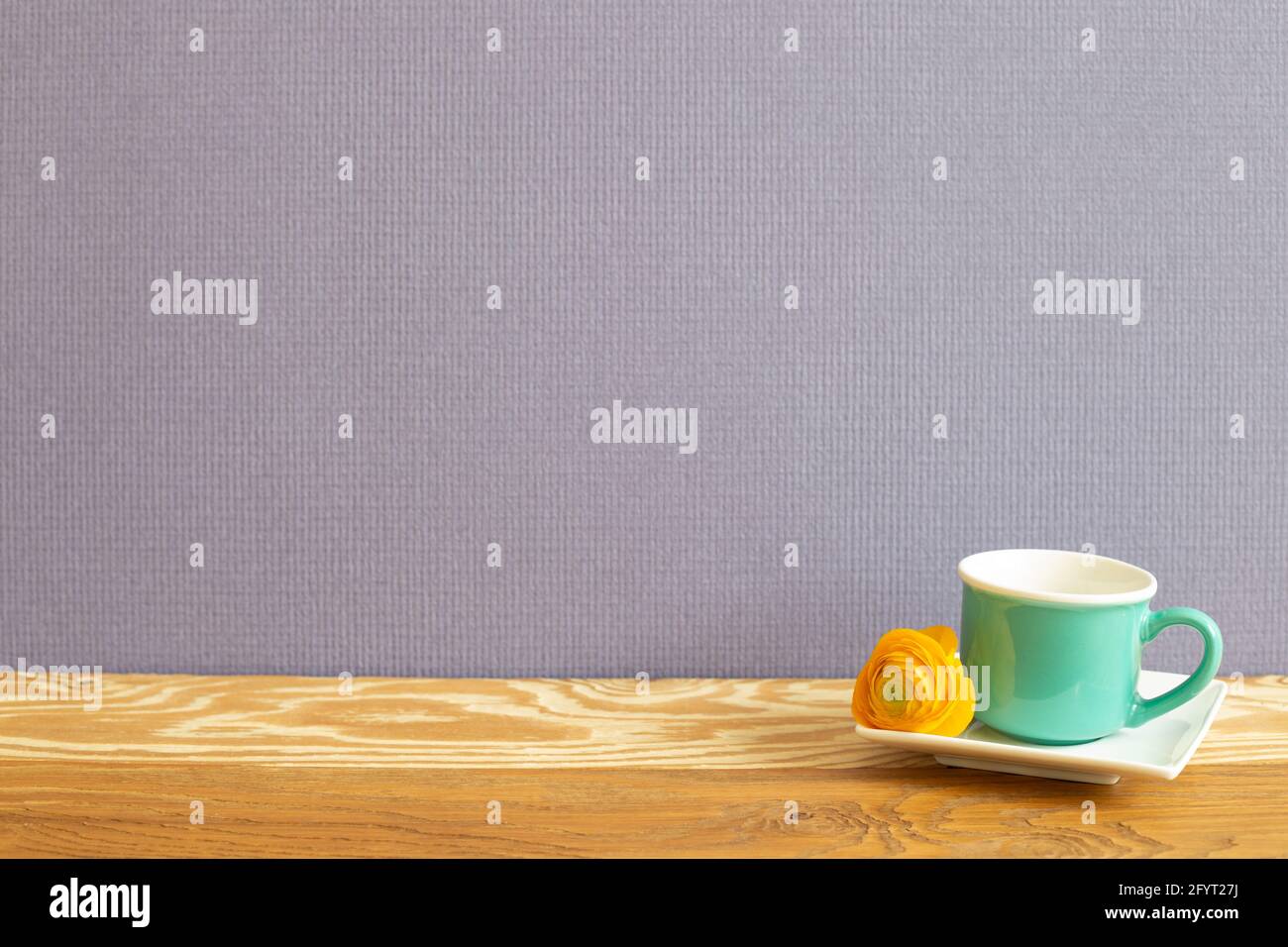 Mint green coffee cup with yellow flower on wooden table. purple ...