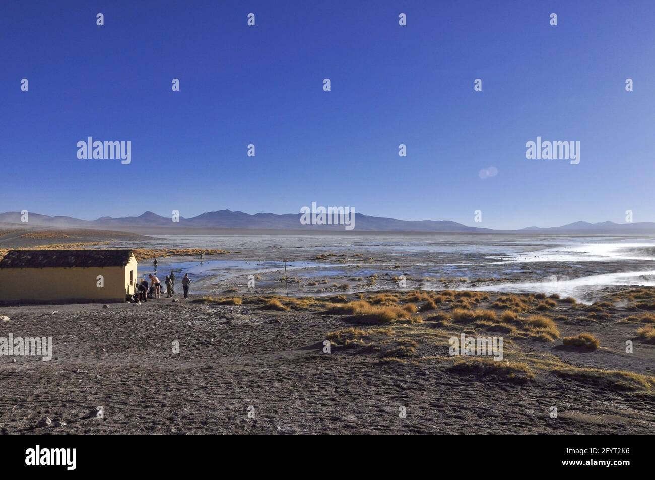 UYUNI, BOLIVIA - May 08, 2021: Group of people waiting around a hut to ...