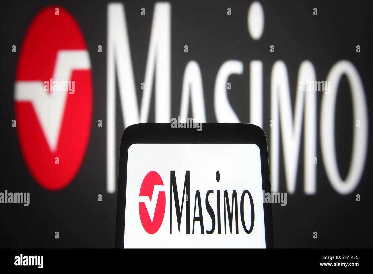 In this photo illustration, Masimo logo seen on a smartphone and a pc ...