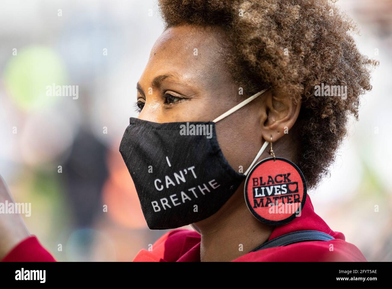 Protestor wearing a face mask written I can’t breathe with an earring ...