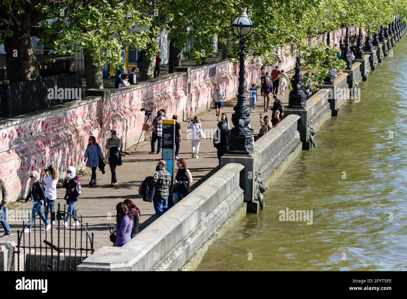 People walking along the River Thames in London. (Photo by May James ...